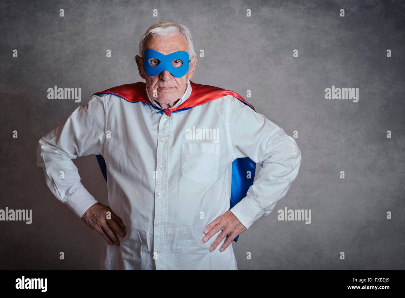 senior man dressed as a superhero on gray background Stock Photo - Alamy