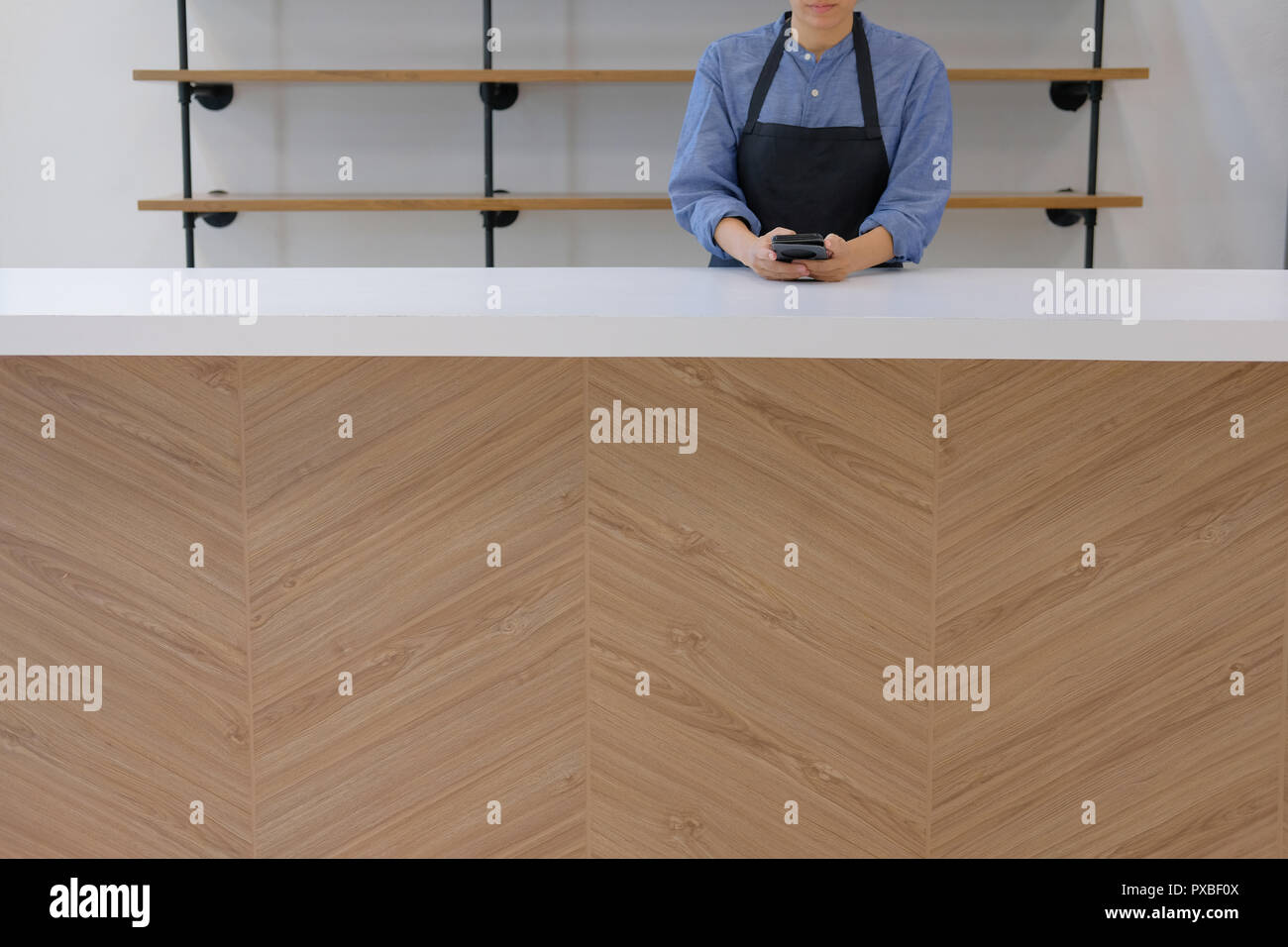 business owner wearing apron holding mobile phone at counter bar. man ...