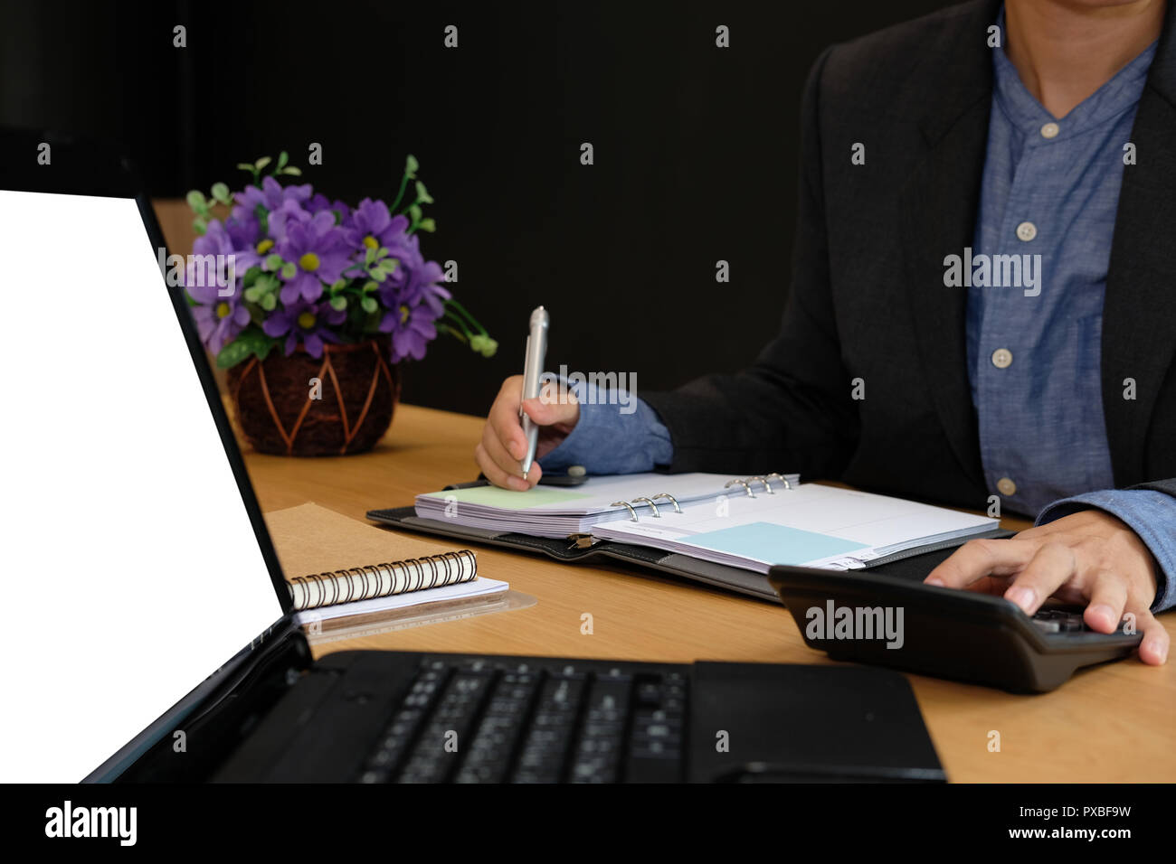 financial adviser working with calculator & notebook at office ...