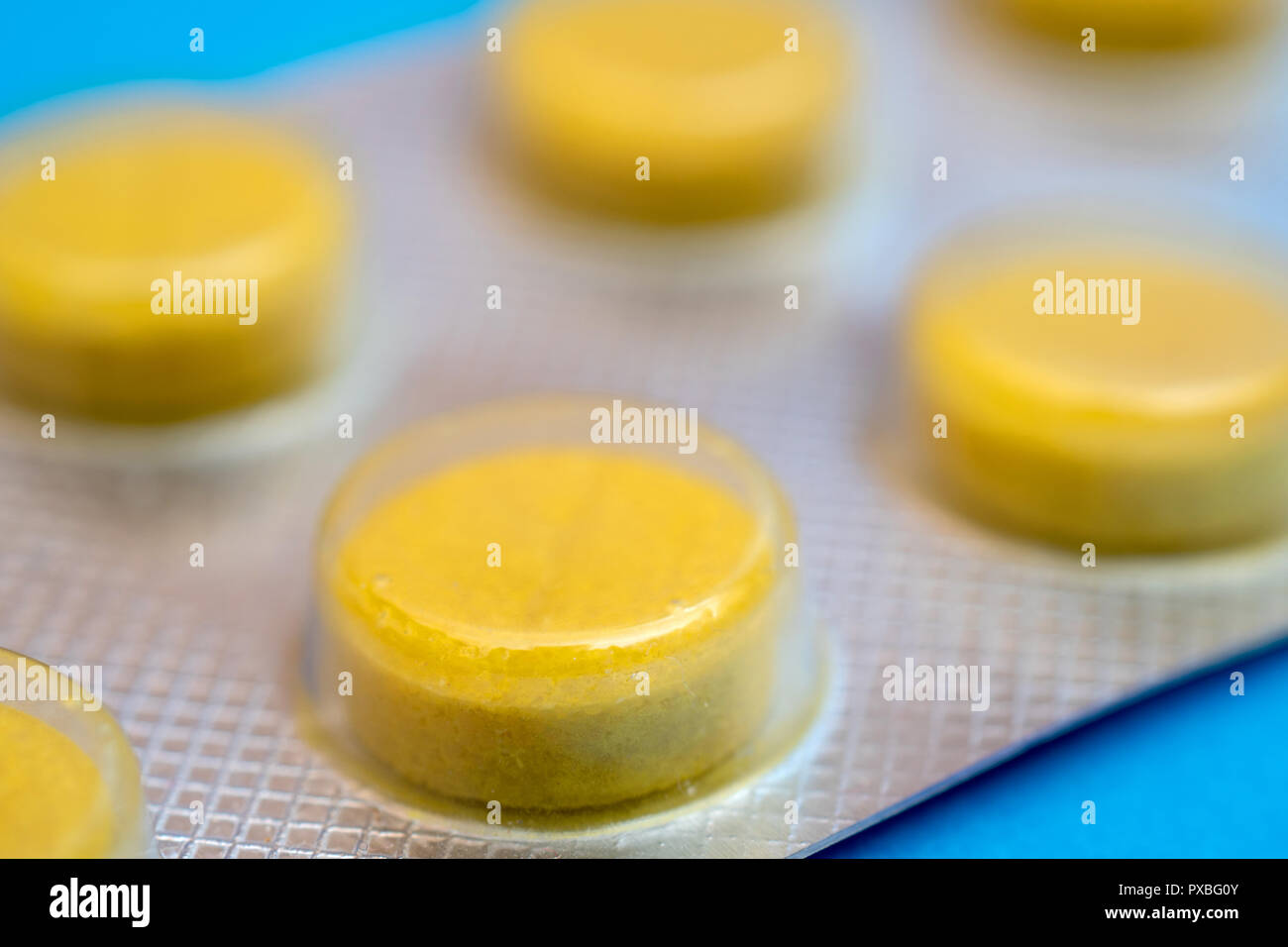 Round, yellow tablets in a package Stock Photo - Alamy