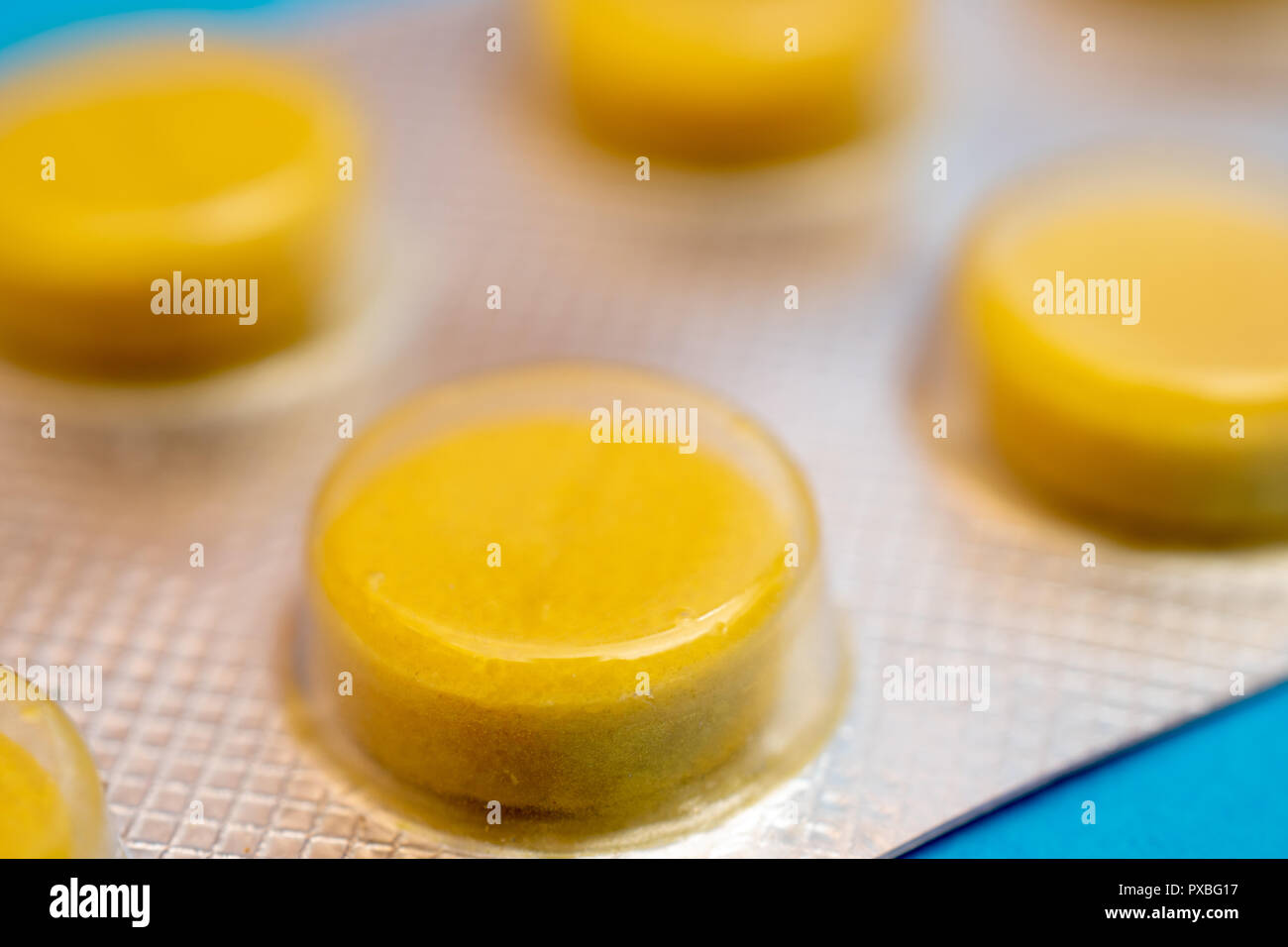 Round, yellow tablets in a package Stock Photo - Alamy