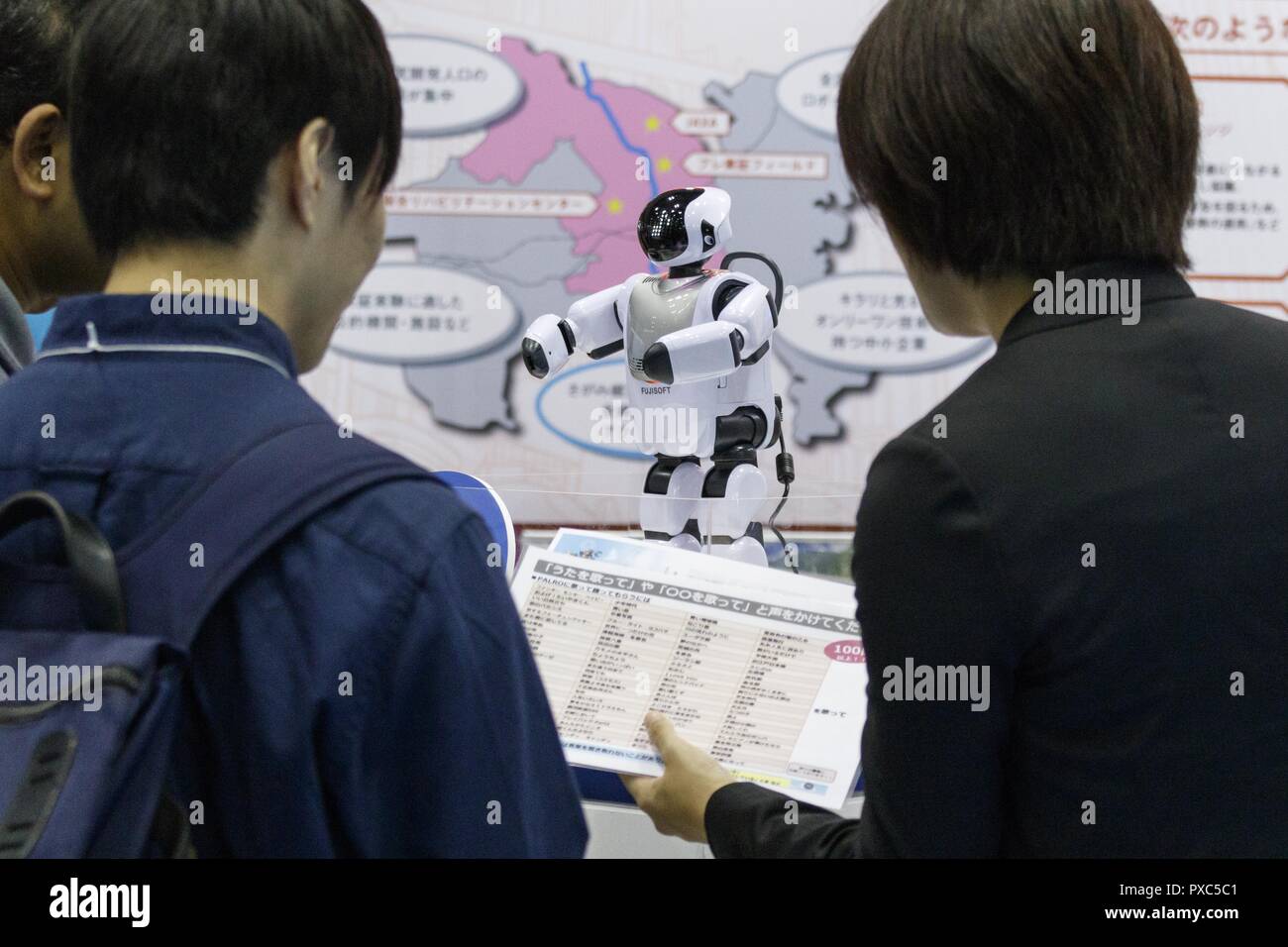 Tokyo, Japan. 21st Oct, 2018. Visitors look at a Fujisoft robot on ...