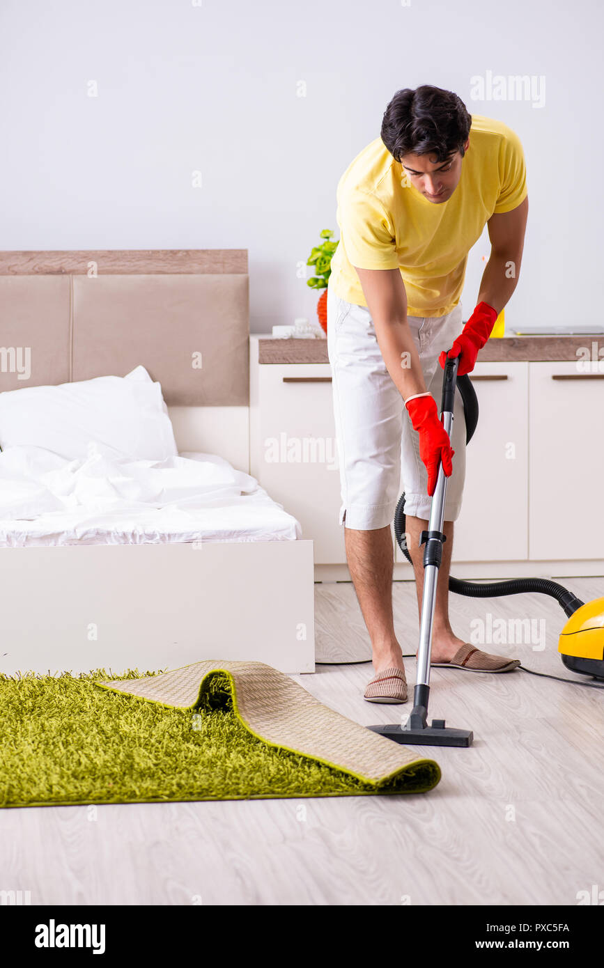 Young handsome man cleaning in the bedroom Stock Photo - Alamy