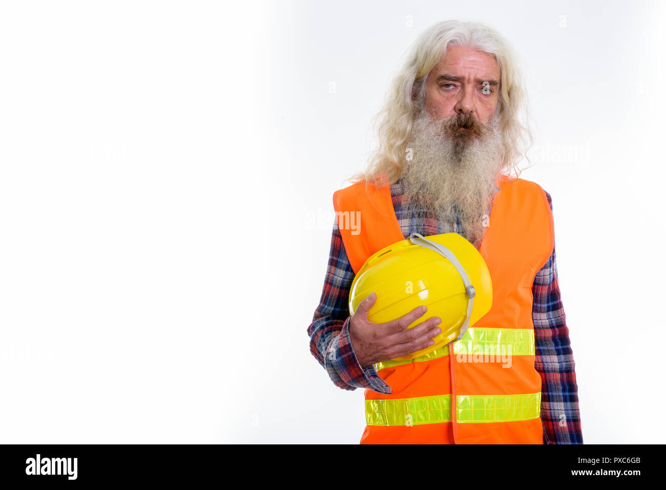 Studio shot of senior bearded man construction worker holding ha Stock ...