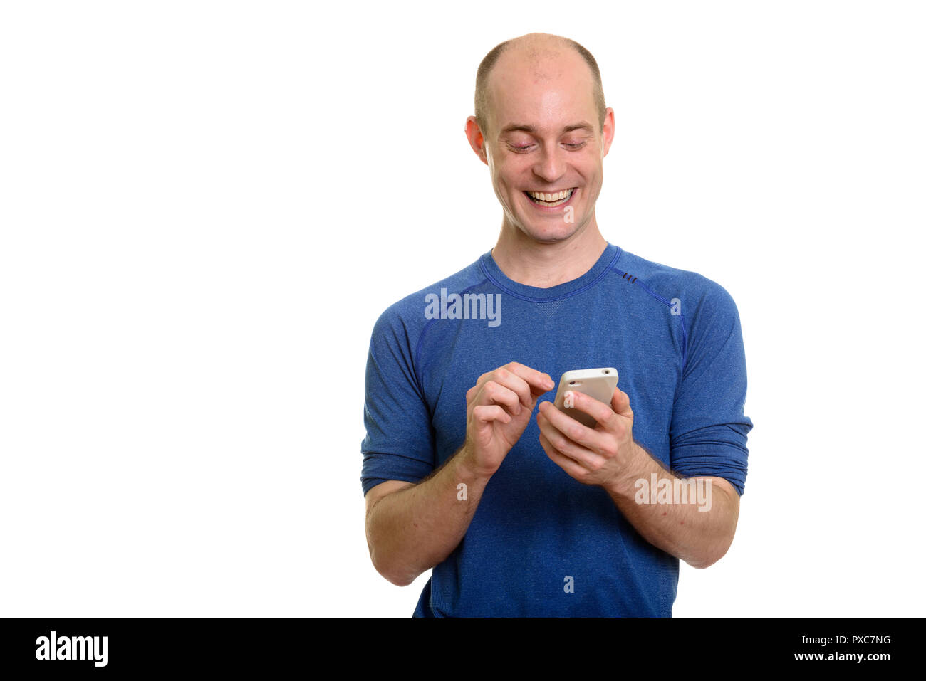 Happy bald Caucasian man smiling and using mobile phone Stock Photo - Alamy