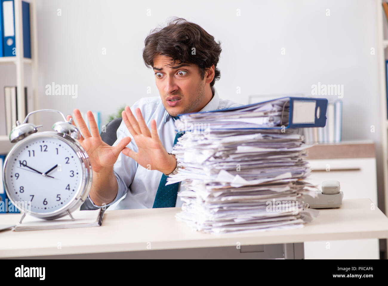 Overloaded busy employee with too much work and paperwork Stock Photo ...