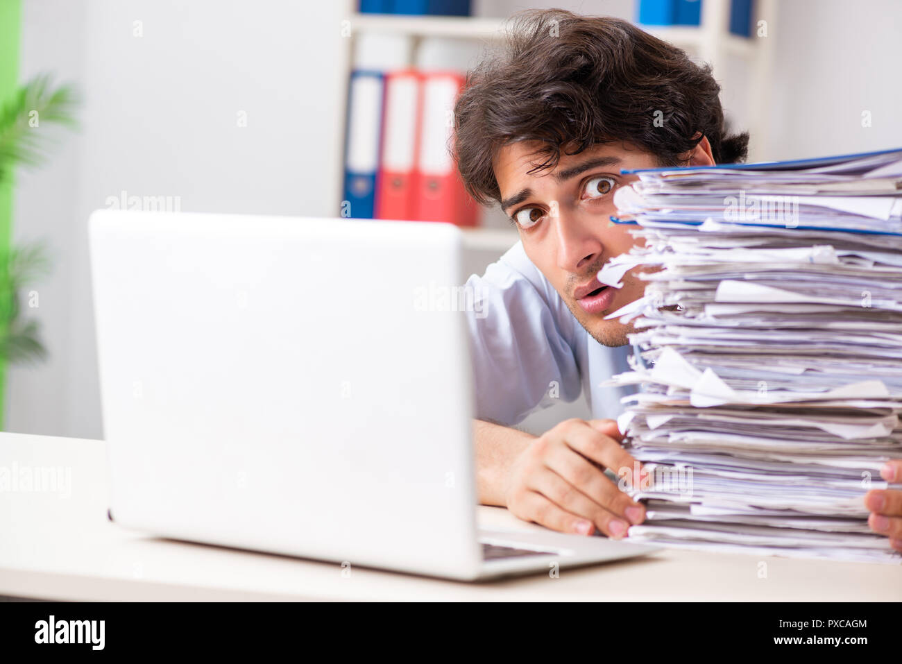 Overloaded busy employee with too much work and paperwork Stock Photo ...