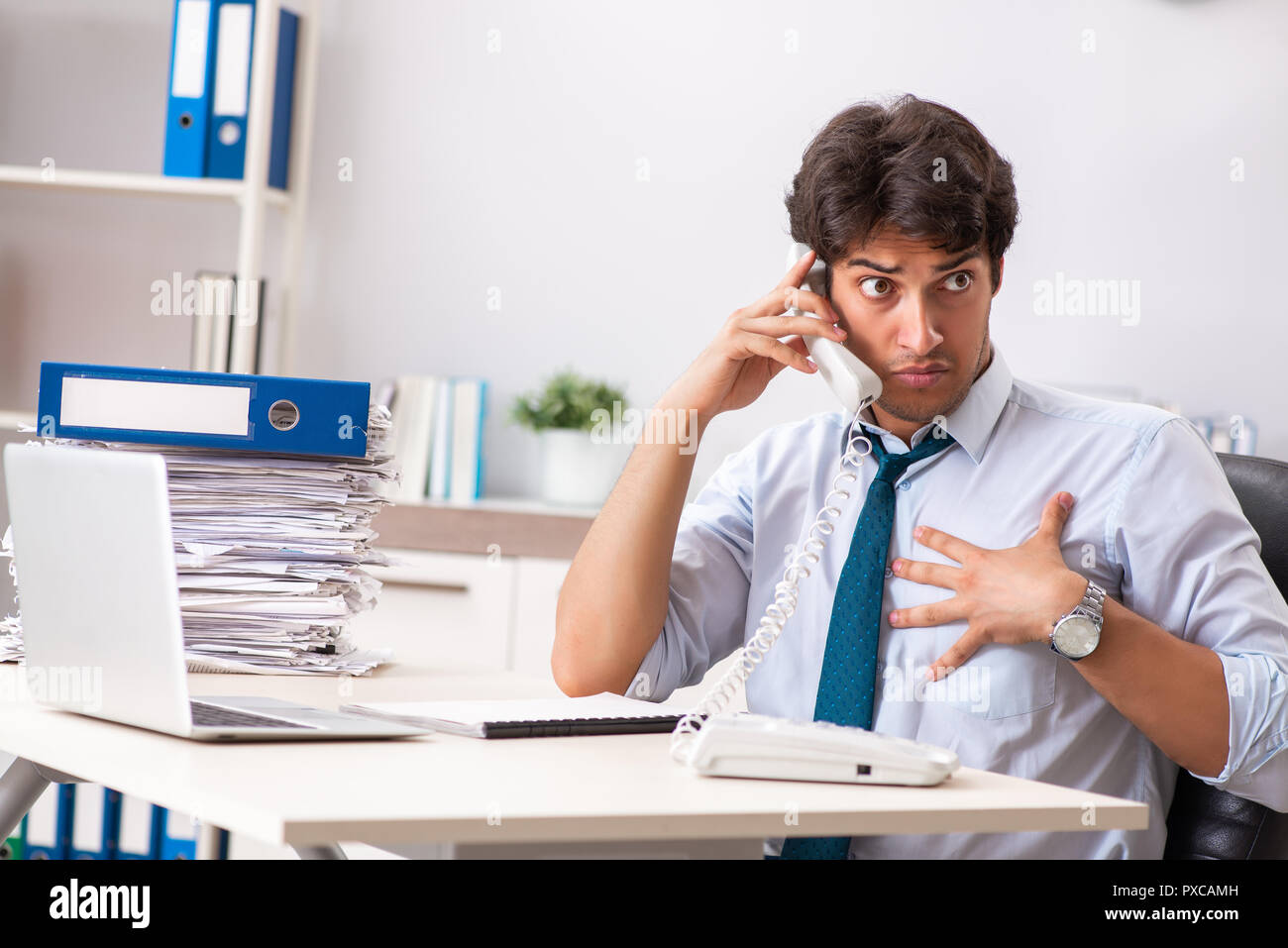 Overloaded busy employee with too much work and paperwork Stock Photo ...