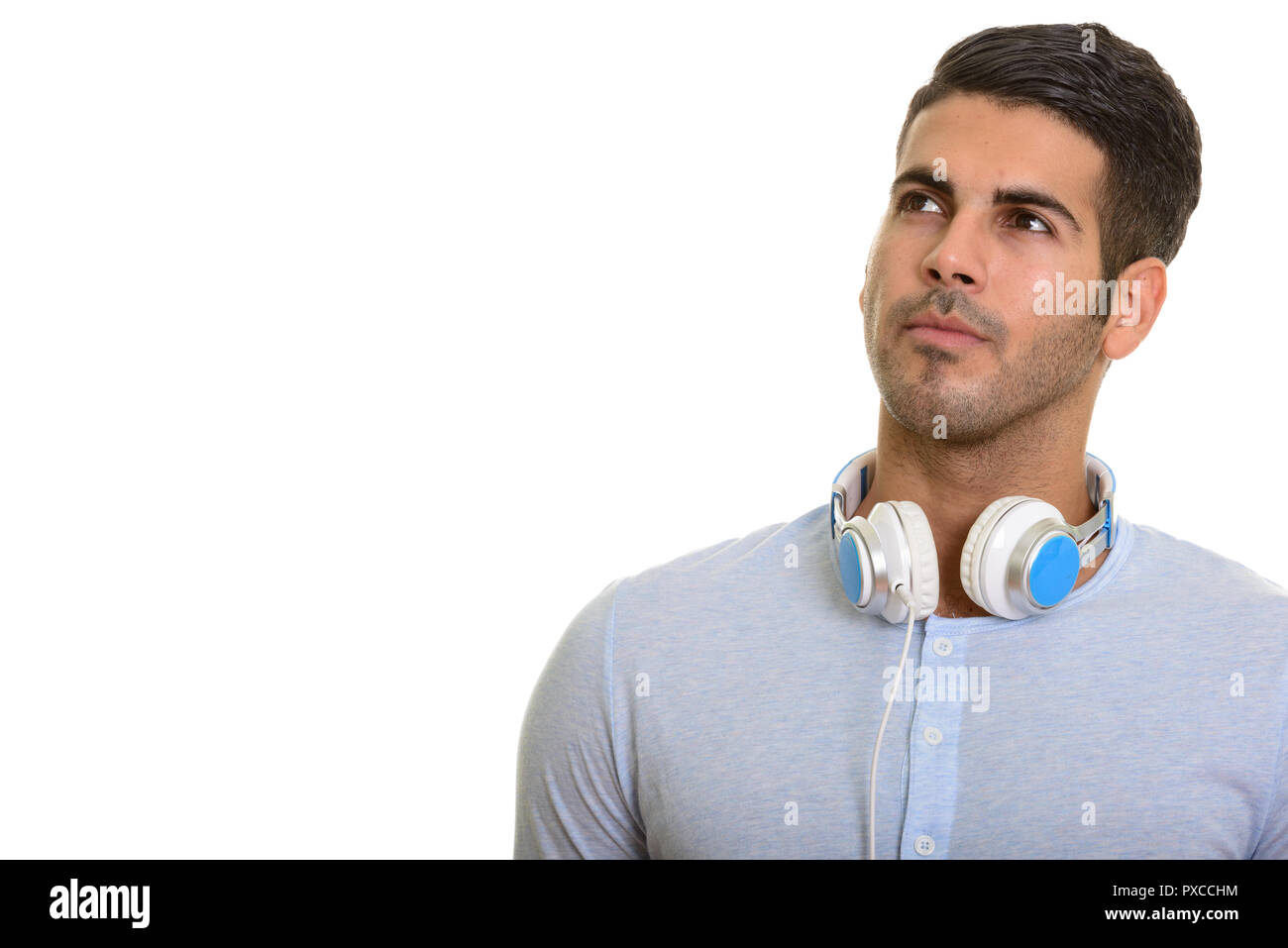 Young handsome Persian man thinking while wearing headphones aro Stock ...