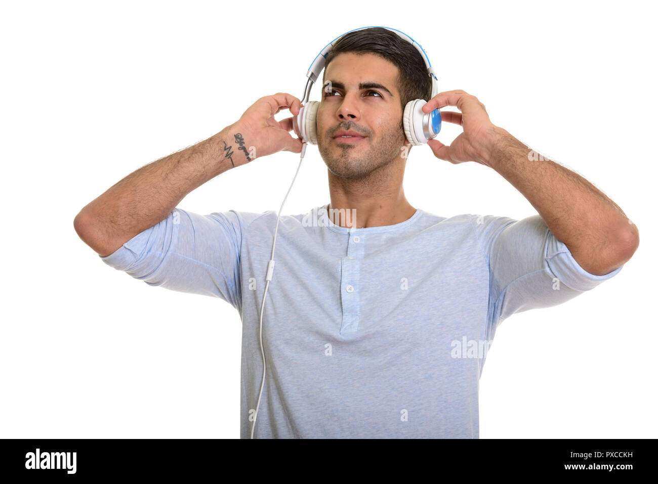 Young happy Persian man smiling while listening to music Stock Photo ...