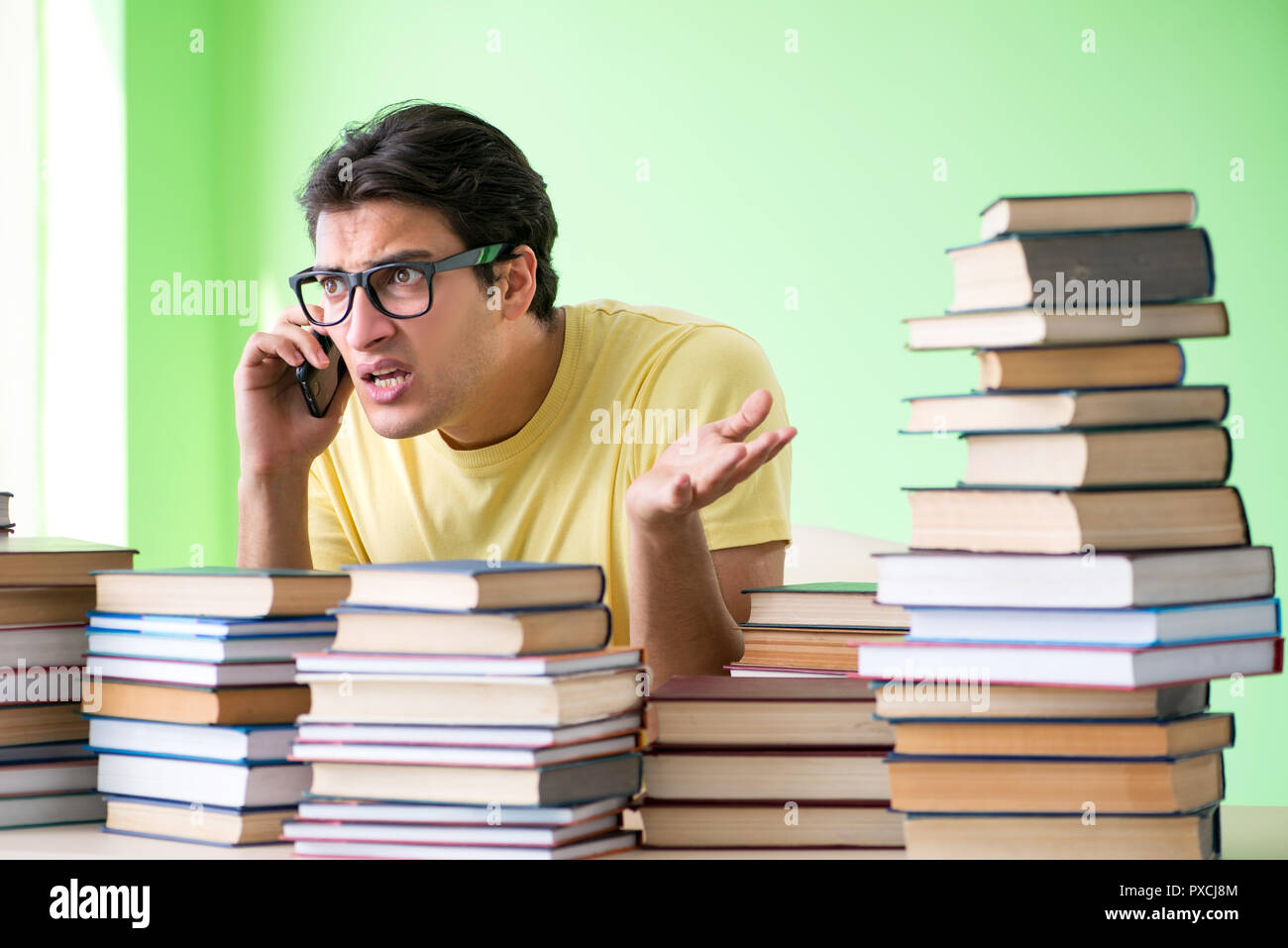 Student with too many books to read before exam Stock Photo - Alamy