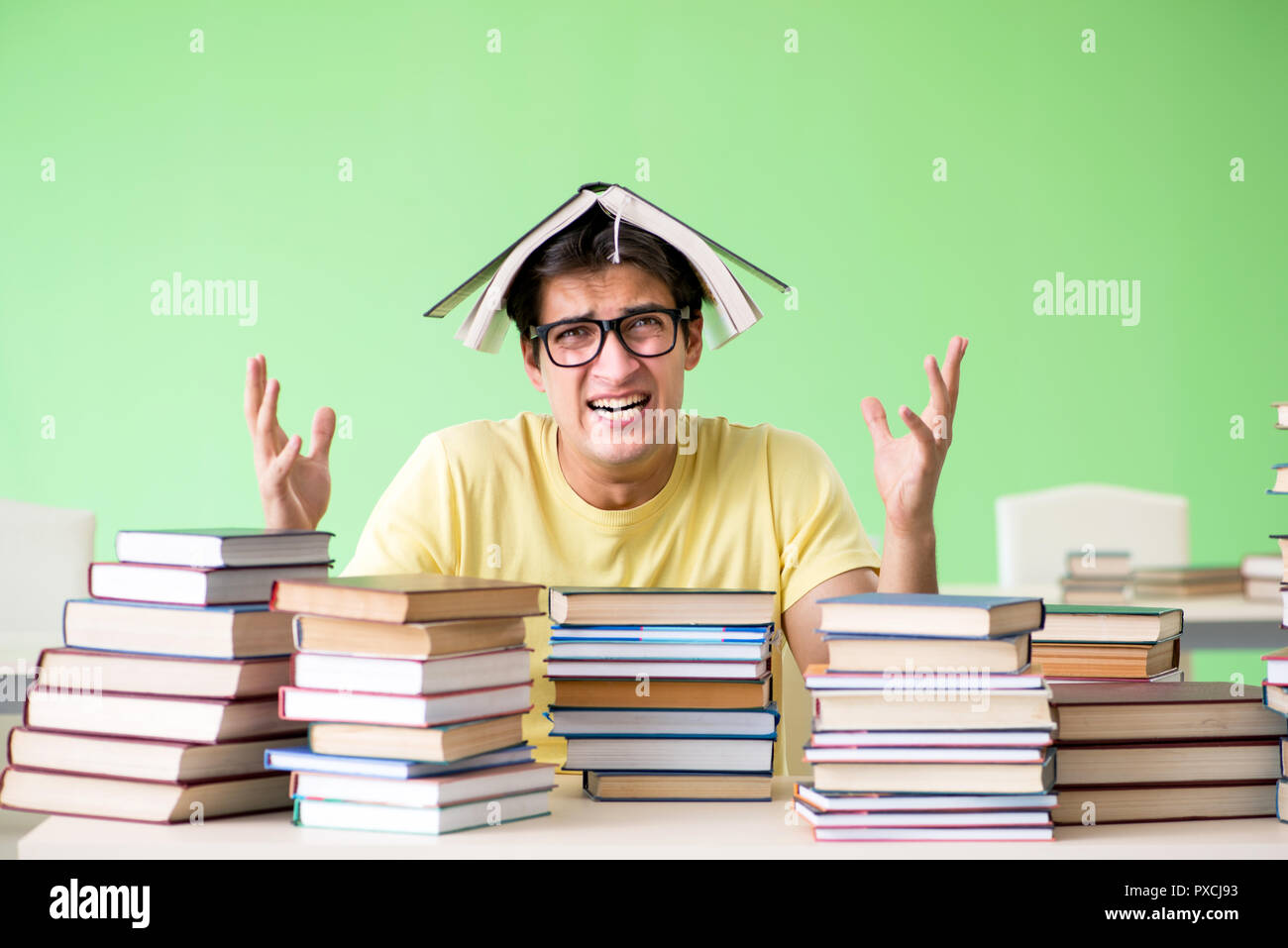 Student with too many books to read before exam Stock Photo - Alamy