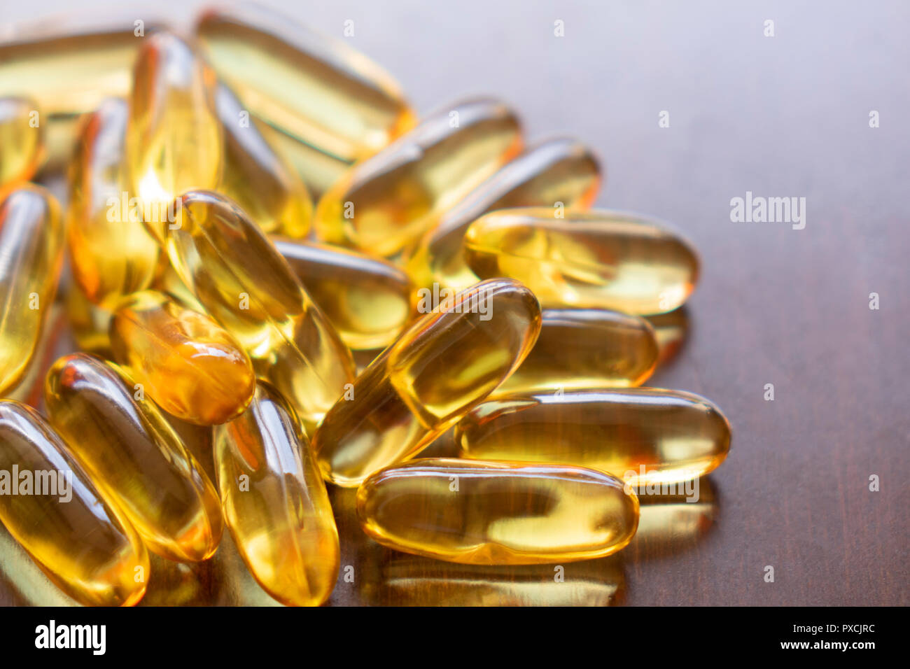 Fish oil omega 3 gel capsules on wooden background Stock Photo - Alamy