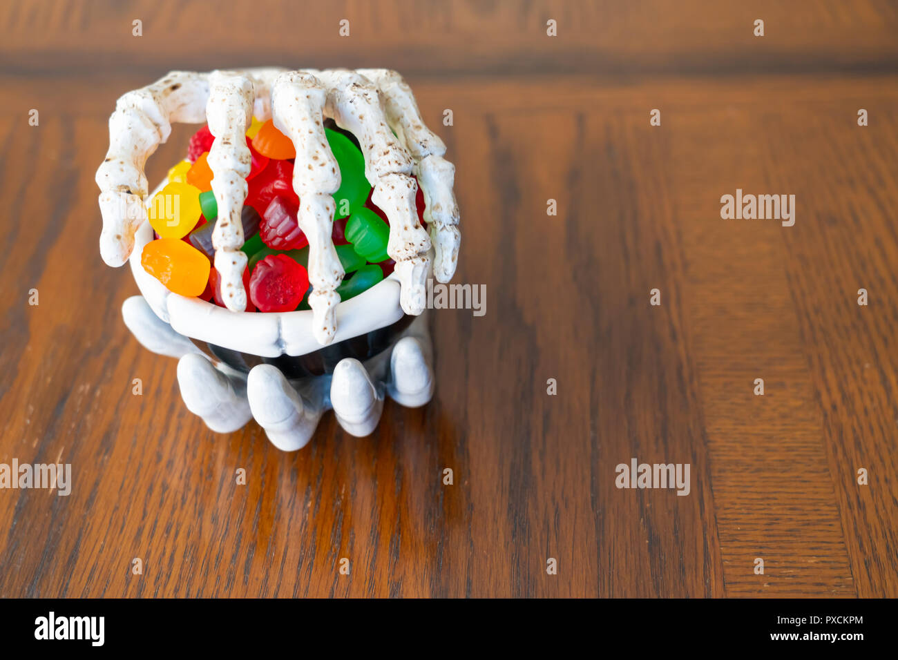 Skeleton hand with bowl of Candy during halloween Stock Photo - Alamy