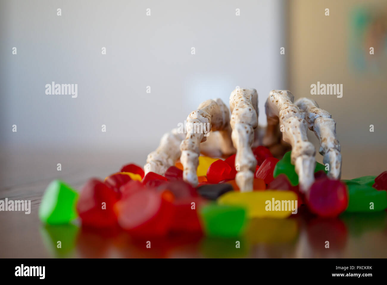 Skeleton hand with bowl of Candy during halloween Stock Photo - Alamy