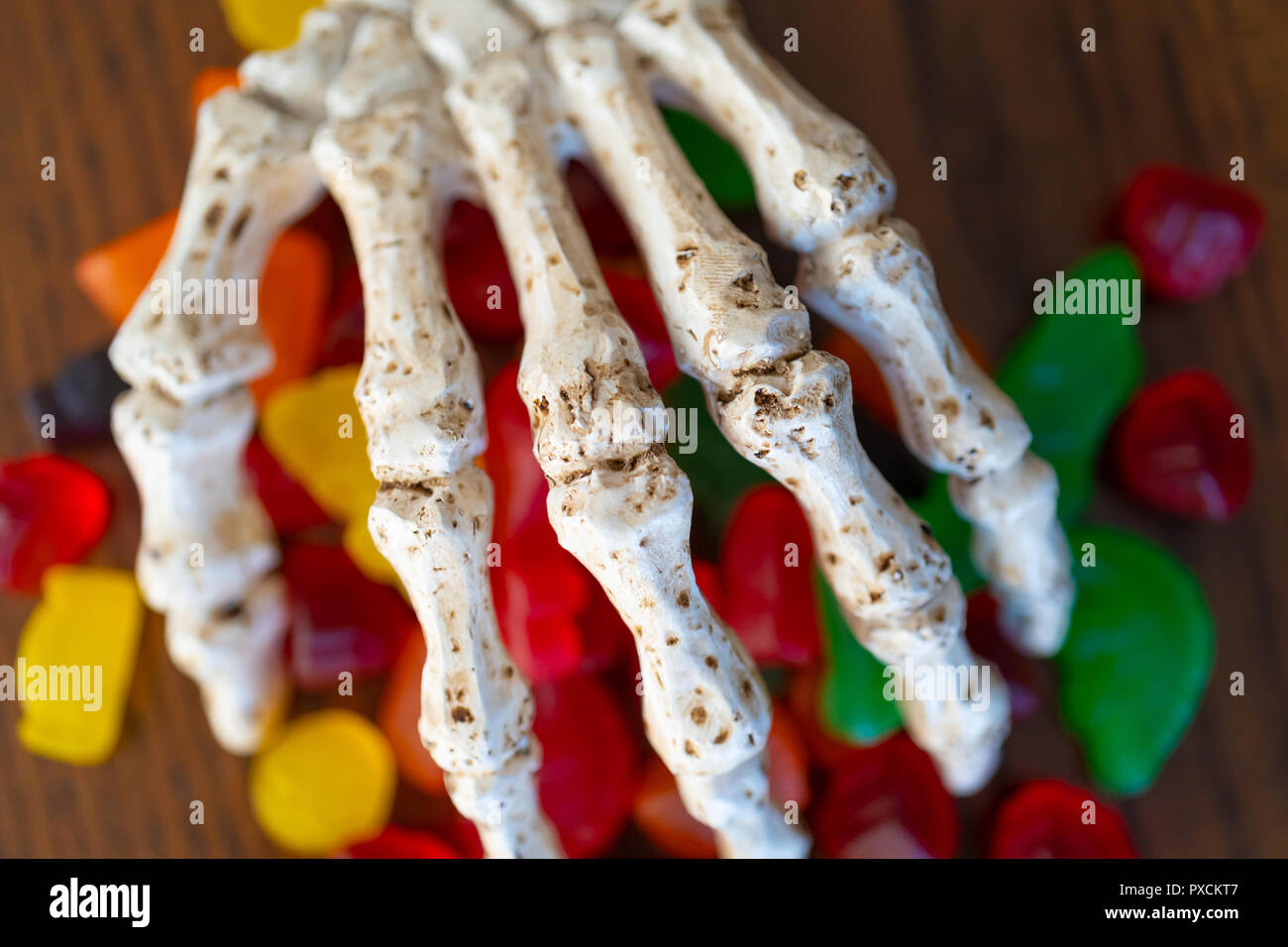 Skeleton hand with bowl of Candy during halloween Stock Photo - Alamy