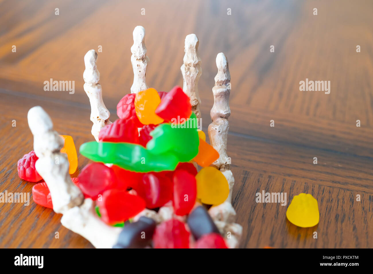 Skeleton hand with bowl of Candy during halloween Stock Photo - Alamy