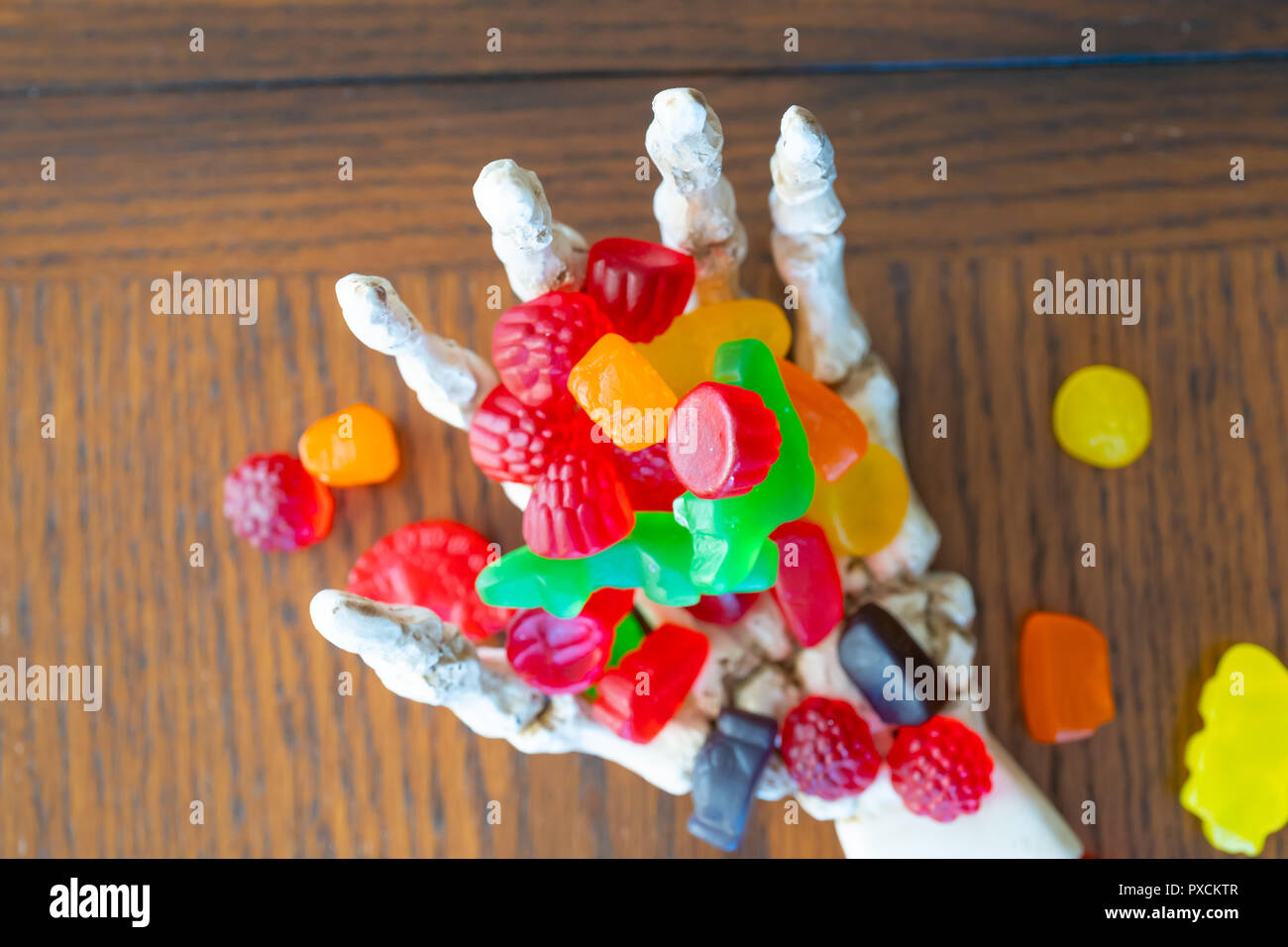Skeleton hand with bowl of Candy during halloween Stock Photo - Alamy
