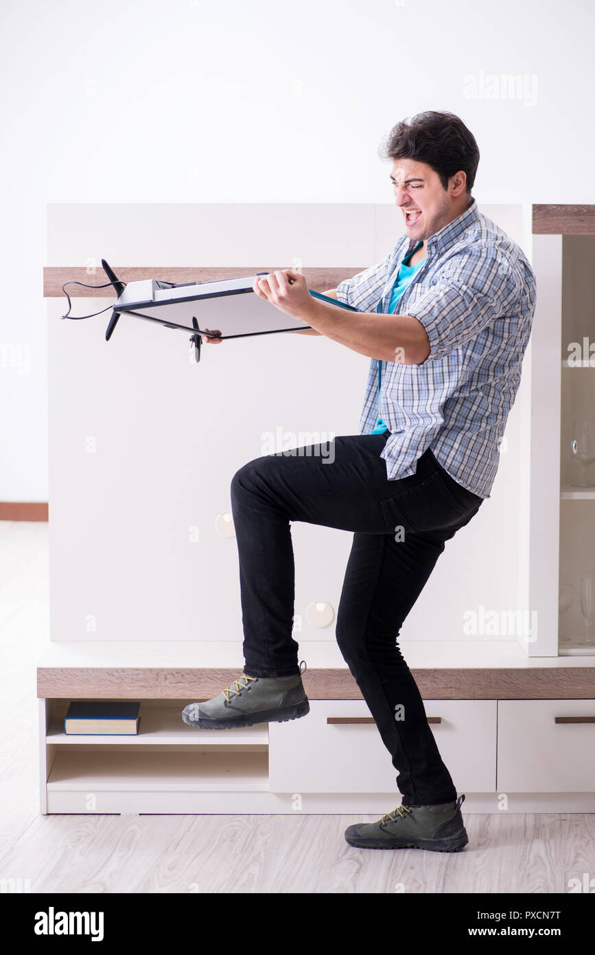 Man trying to fix broken tv Stock Photo - Alamy