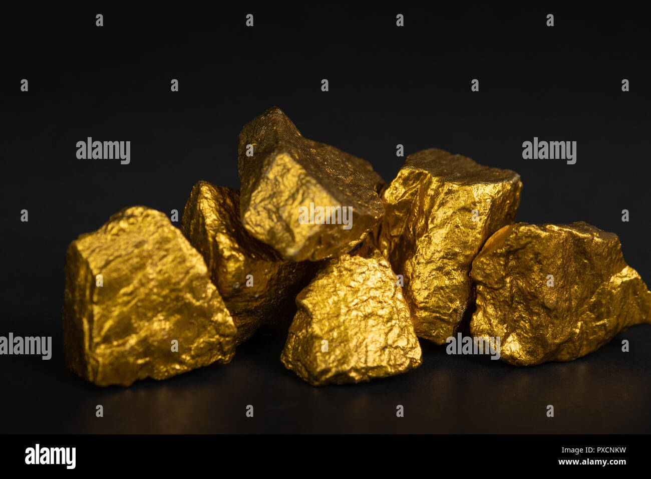 A pile of gold nuggets or gold ore on black background, precious stone ...