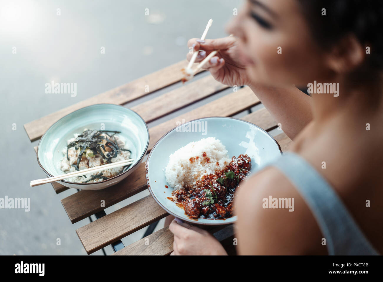 Beautiful woman eating chicken with rice in street cafe of chinese food ...