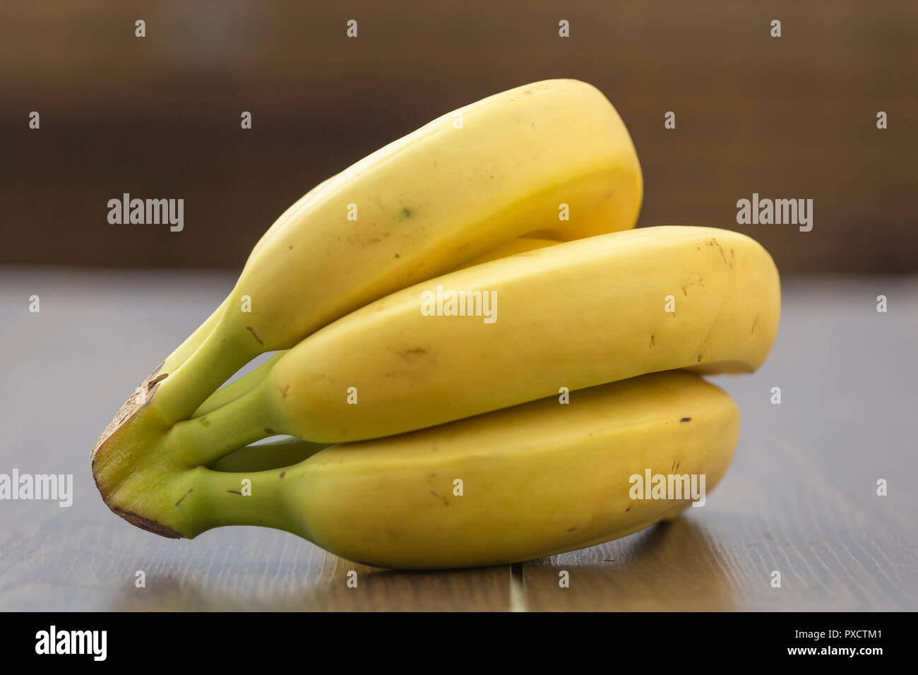 Tropical banana on brown background and surface, warm shades for ...