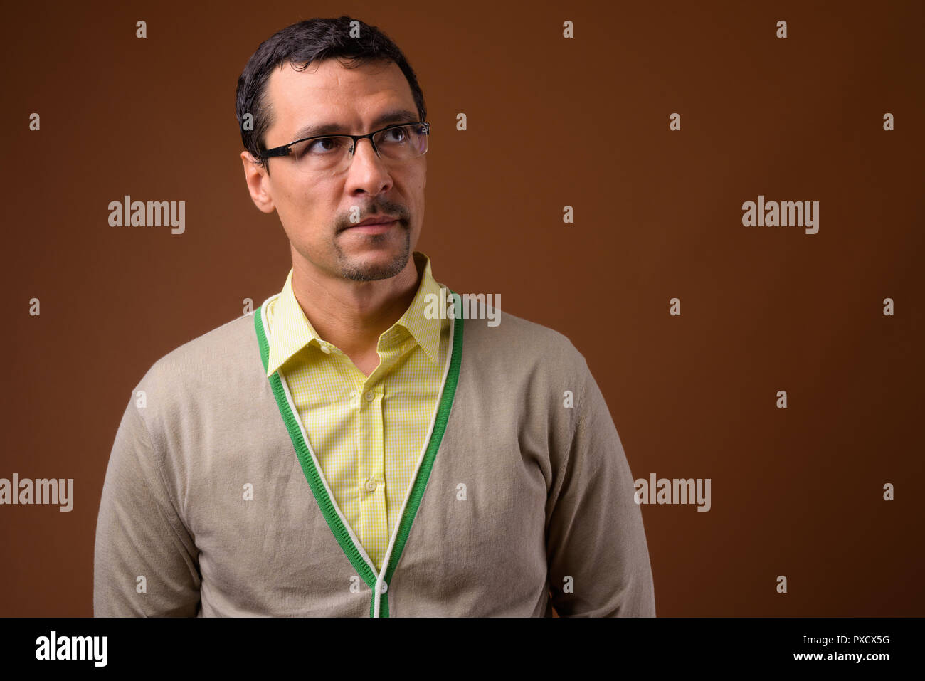 Portrait of handsome man thinking against brown background Stock Photo ...