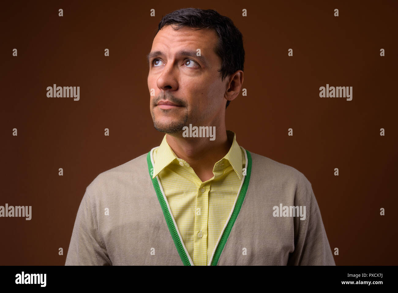 Portrait of handsome man thinking against brown background Stock Photo ...