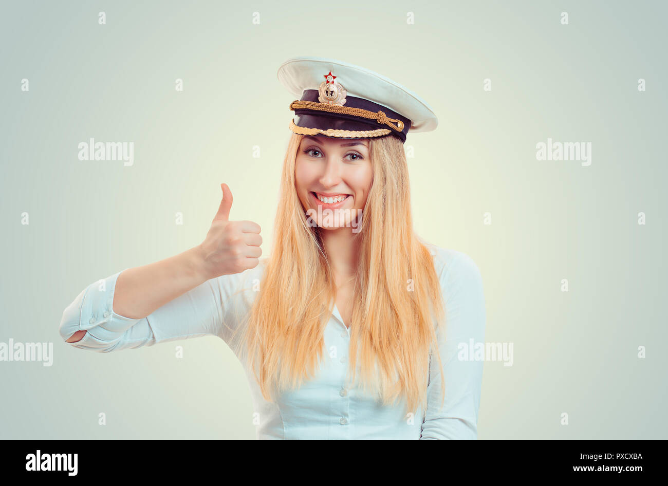 Happy blond woman wearing white shirt and navy service cap showing ...