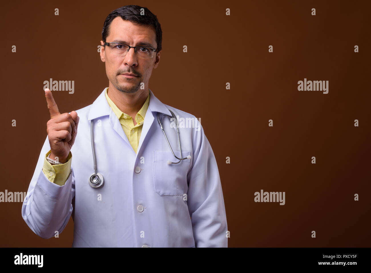 Portrait of handsome man doctor pointing finger up Stock Photo - Alamy