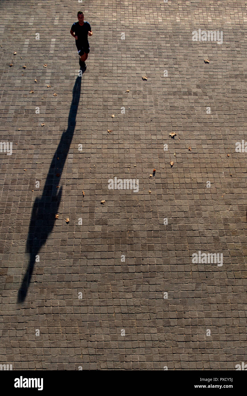 A runner casts a long shadows on an autumnal afternoon Stock Photo - Alamy
