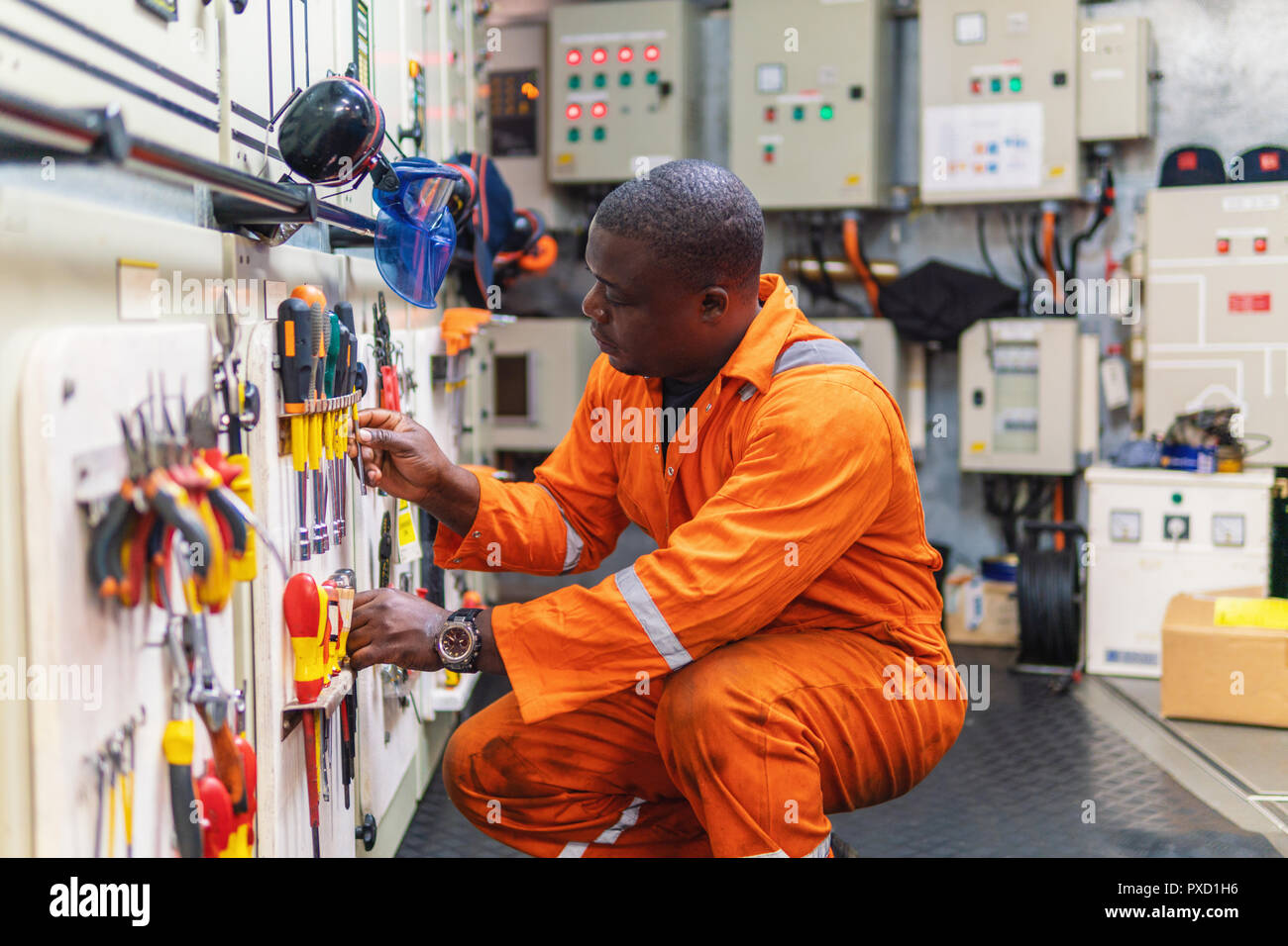Marine engineer officer working in engine room Stock Photo - Alamy