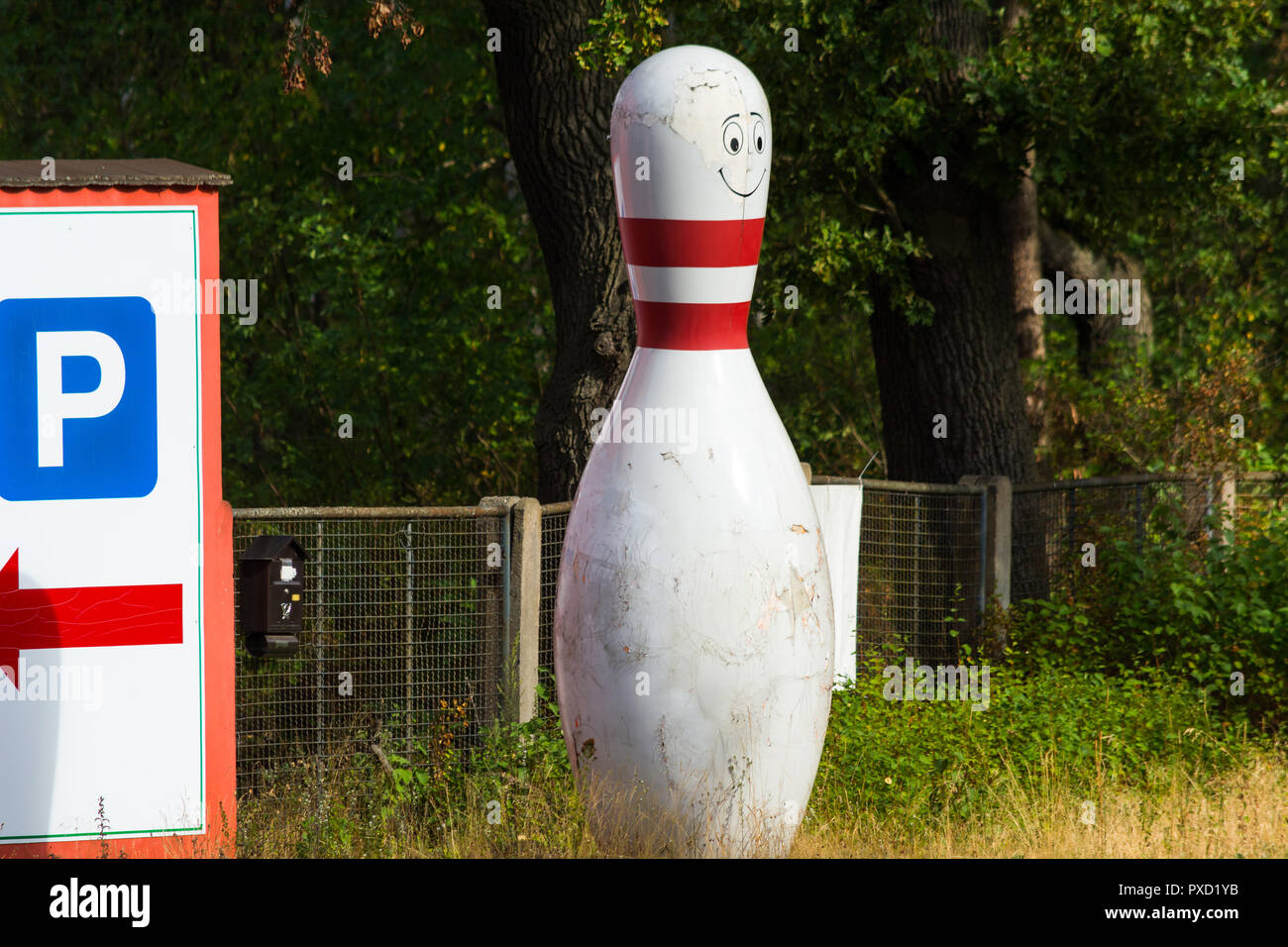 Bowling cone with white and red stripes in front of green background ...
