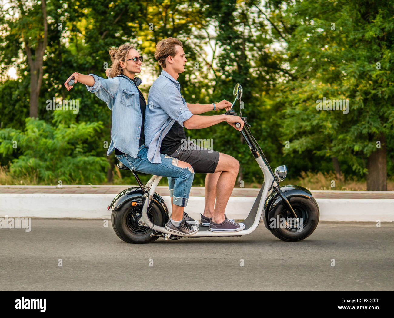 Lovely young couple driving electric bike during summer Stock Photo - Alamy