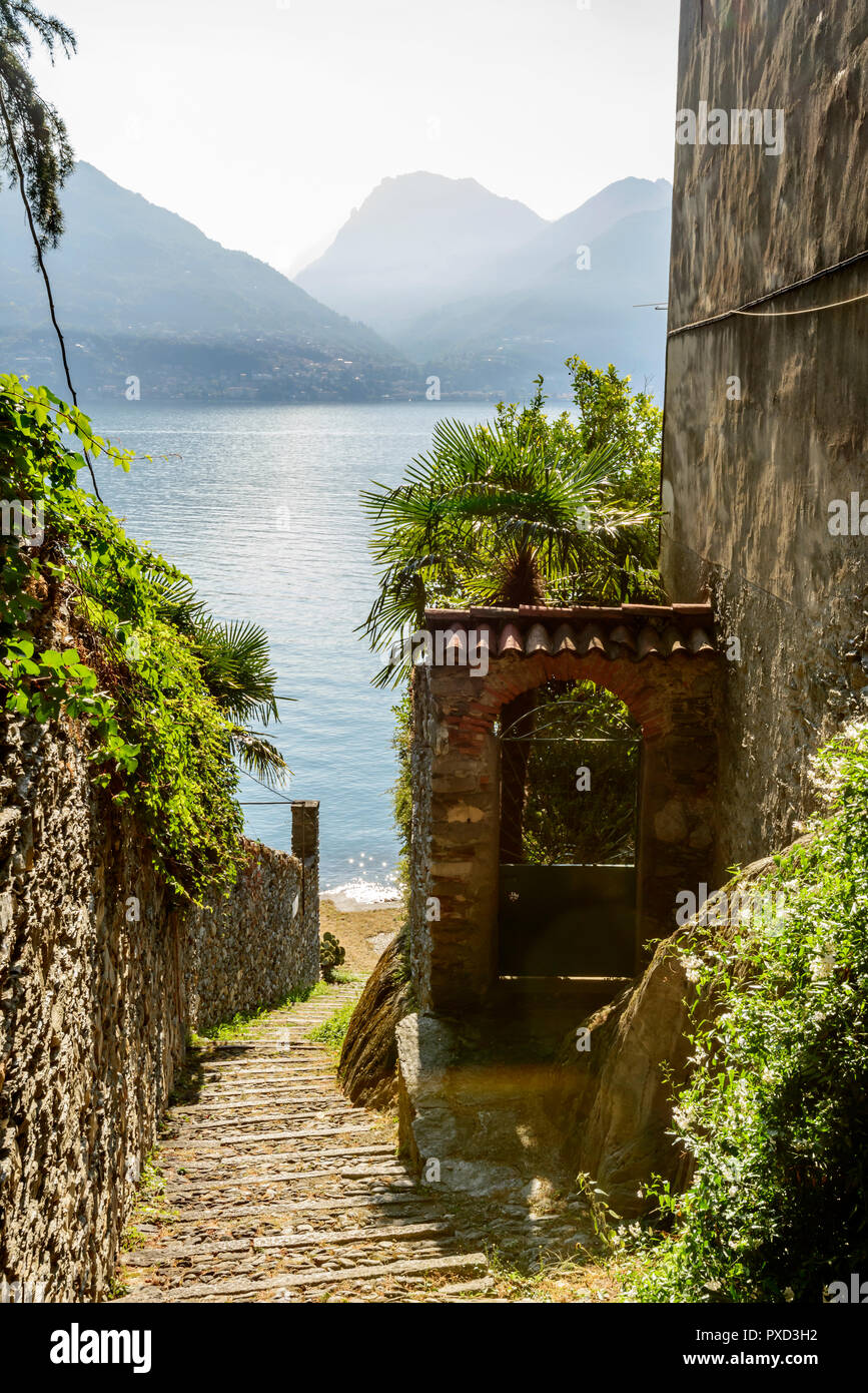 steep stone stair in narrow alley to Como lake at touristic lake ...