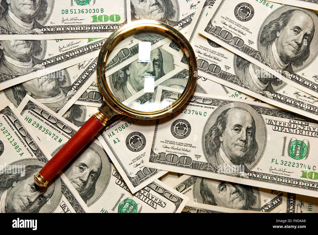 magnifying glass with background of dollars Stock Photo - Alamy
