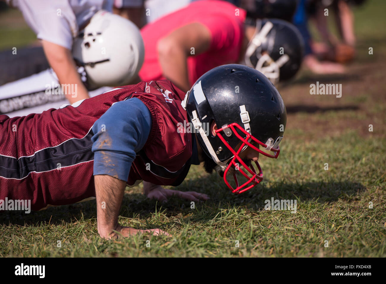 american football team doing push ups during training at the field ...