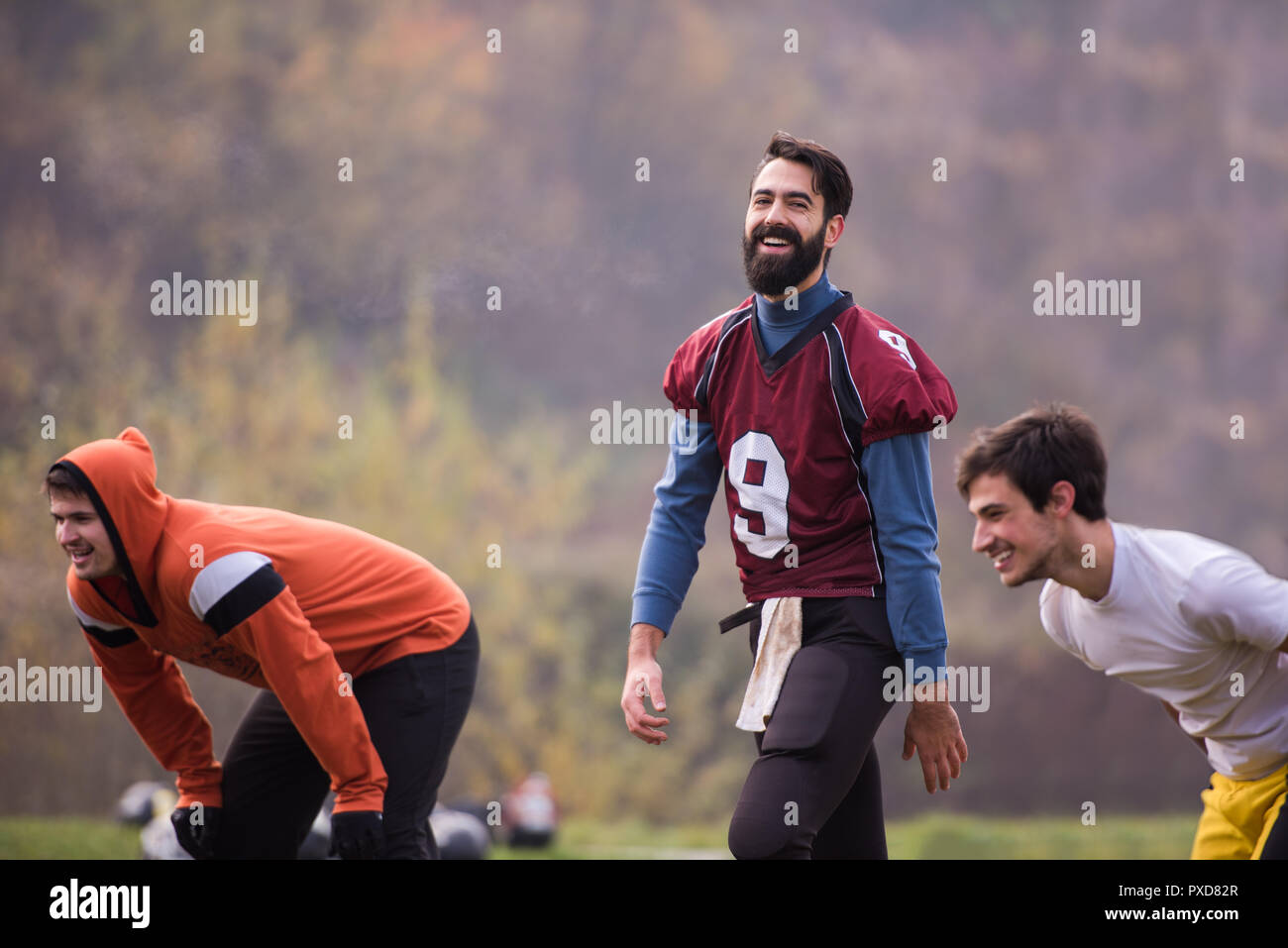 group of young american football players stretching and warming up ...