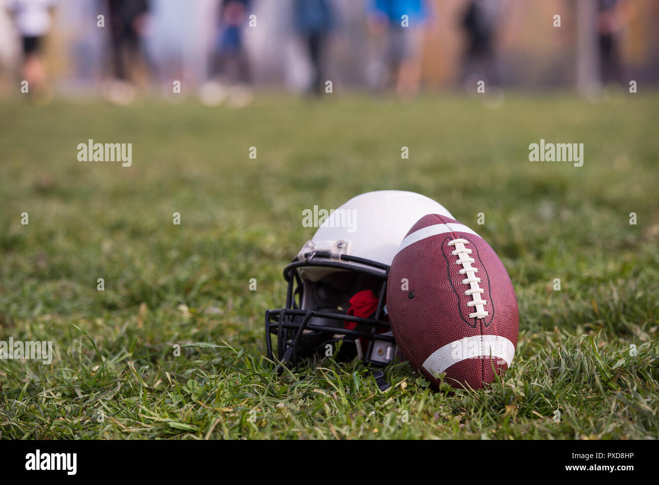 American football helmet and ball lying on field Stock Photo - Alamy