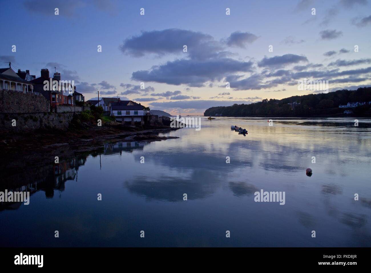 Shoreside properties reflected in the still waters of the Menai Strait ...