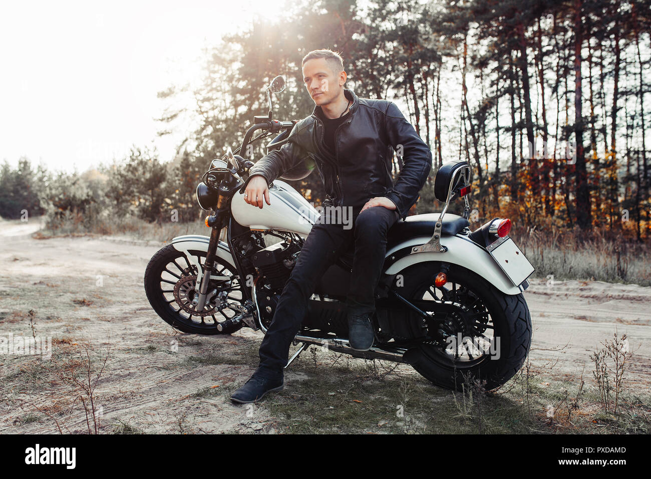 Handsome rider guy in black biker leather jacket on classic style cafe ...