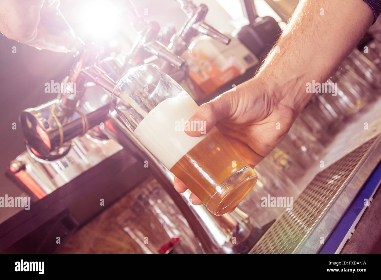 Close up of barman pouring lager beer in drinking glass Stock Photo - Alamy
