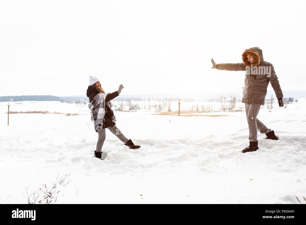 Carefree happy young couple having fun together in snow in winter ...