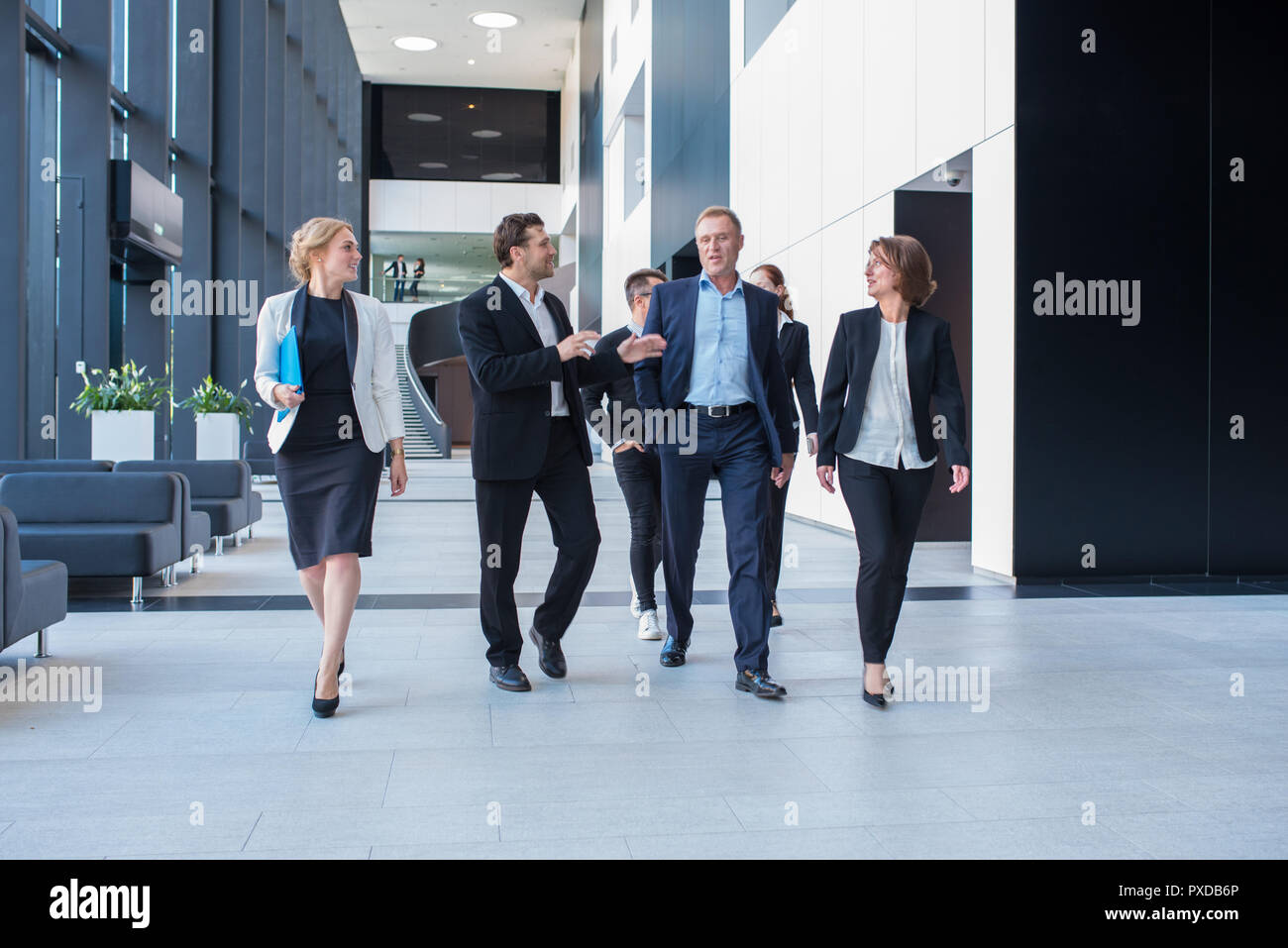 Lively business team walking together in office builging showing ...