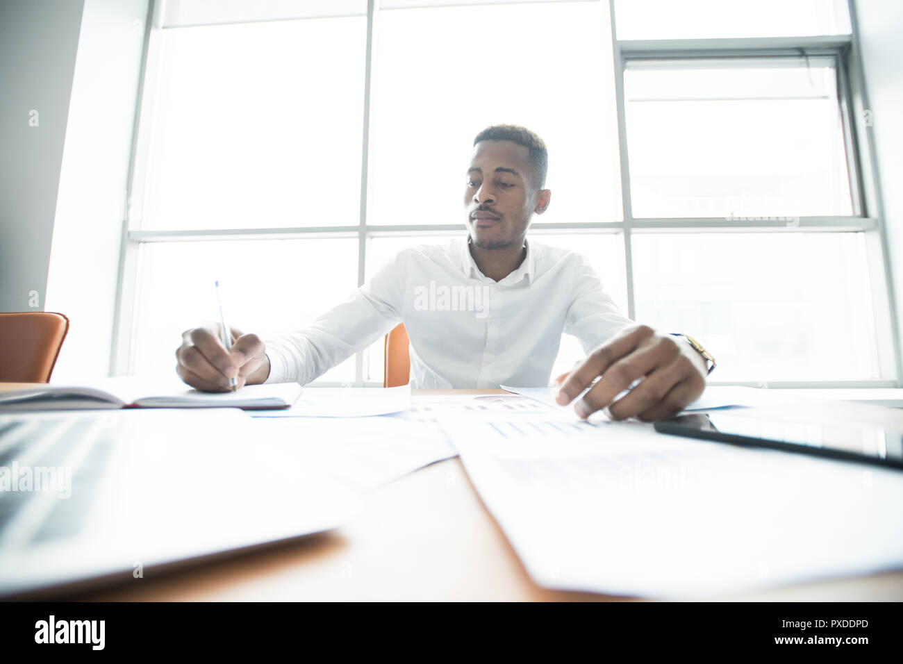 Busy African manager doing business analysis Stock Photo - Alamy