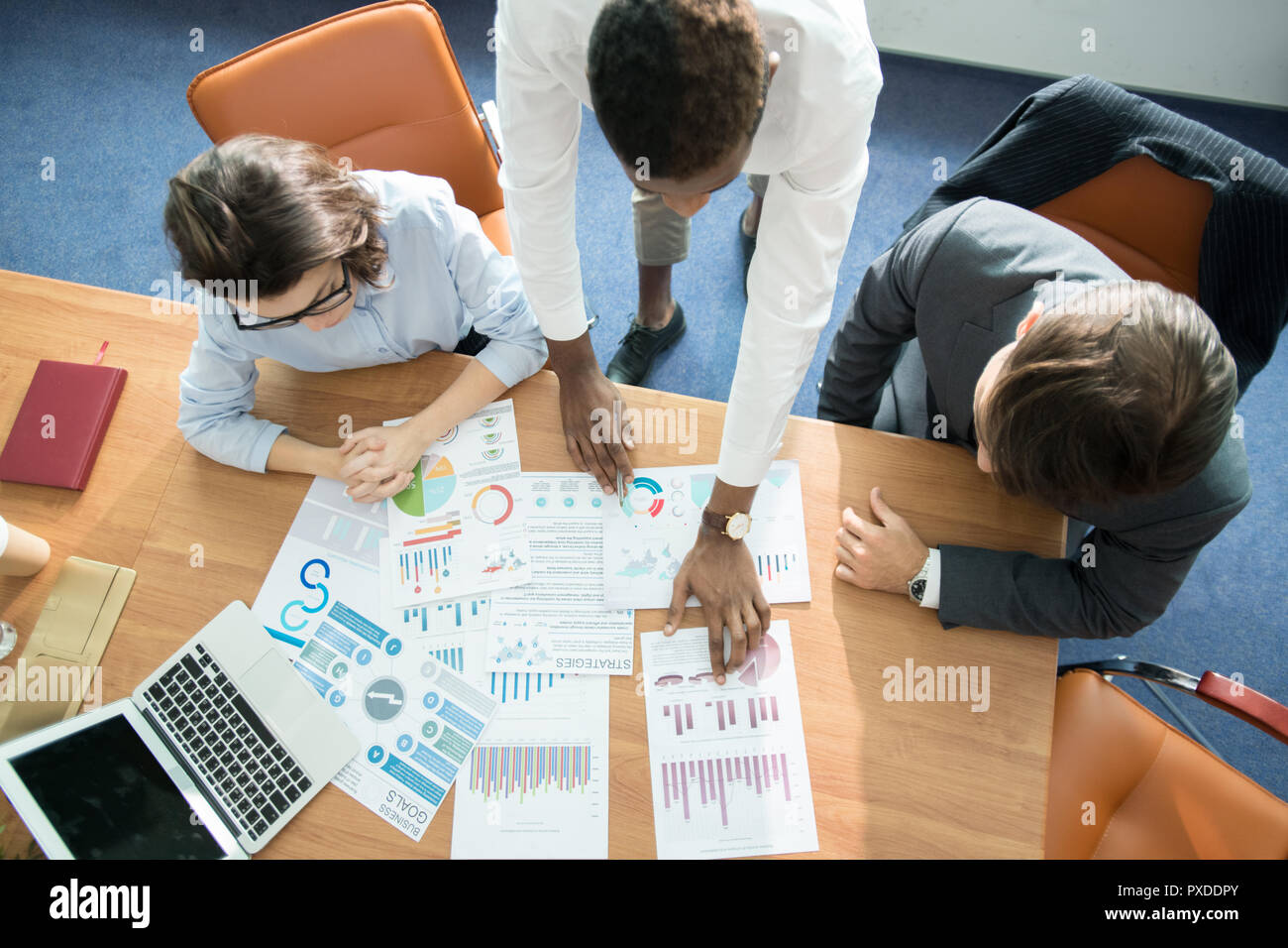 Marketing team analyzing statistics at meeting Stock Photo - Alamy