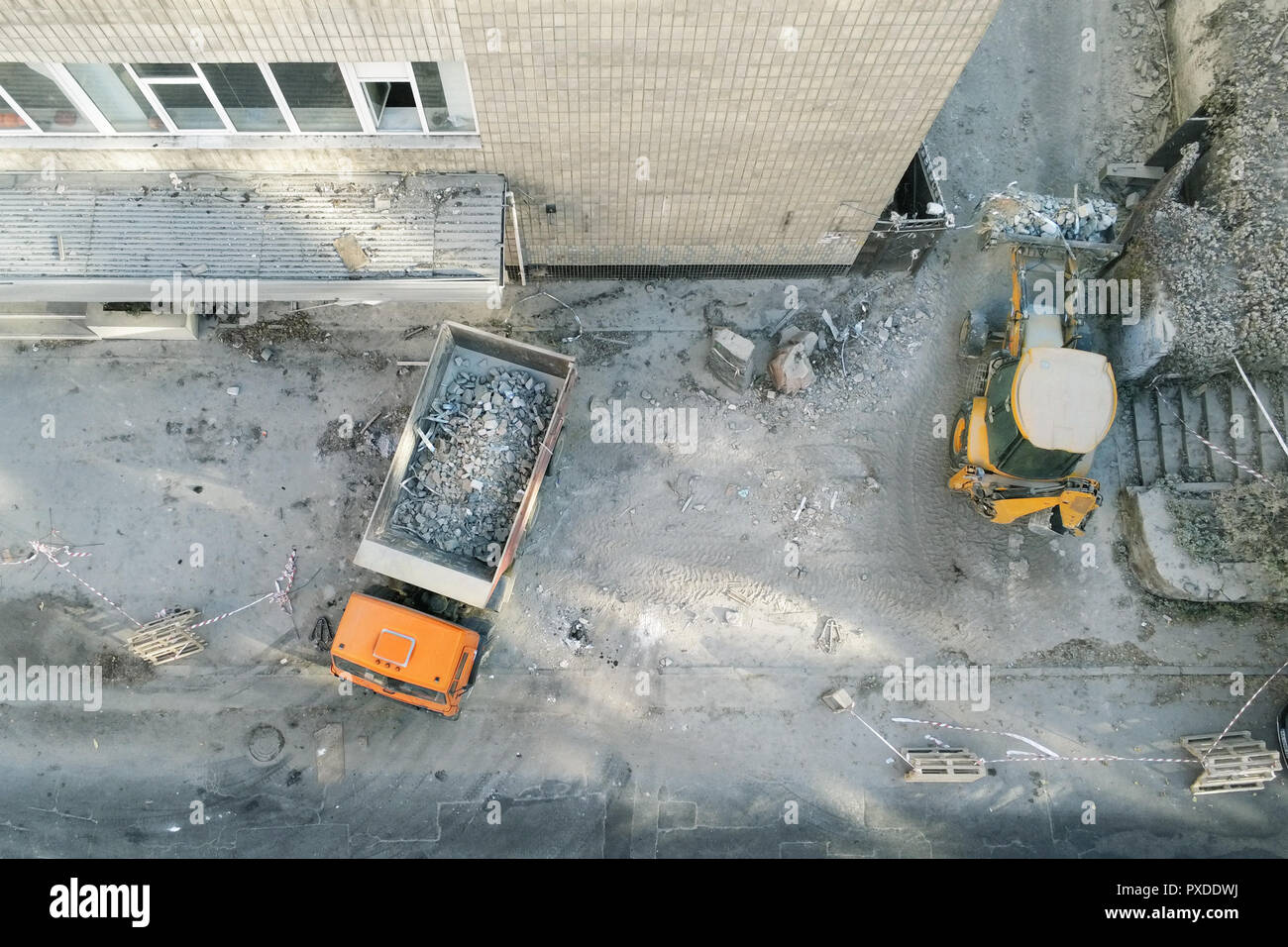 Bulldozer loader uploading waste and debris into dump truck at ...