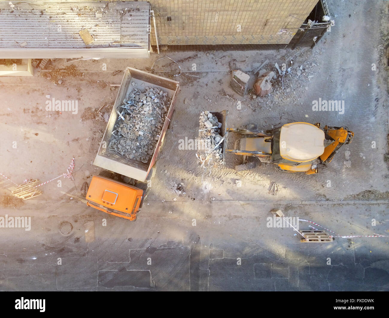 Bulldozer loader uploading waste and debris into dump truck at ...
