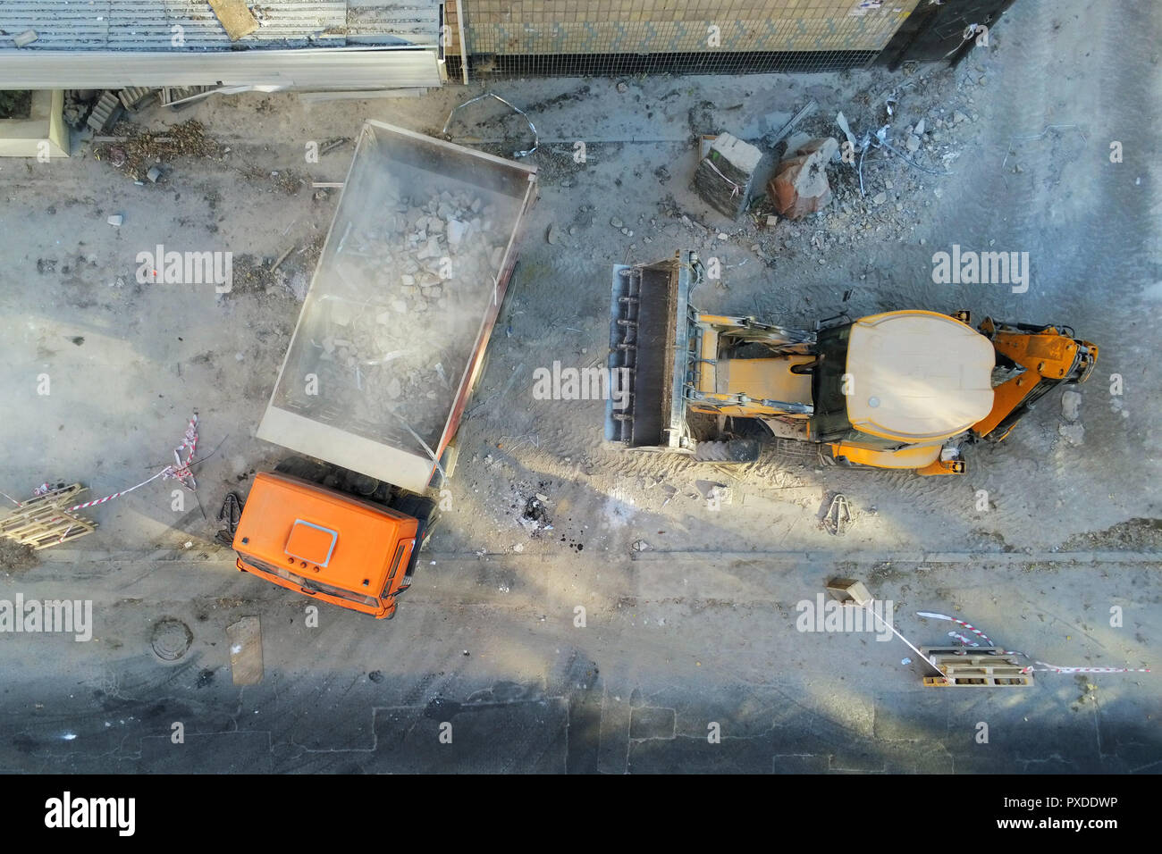 Bulldozer loader uploading waste and debris into dump truck at ...