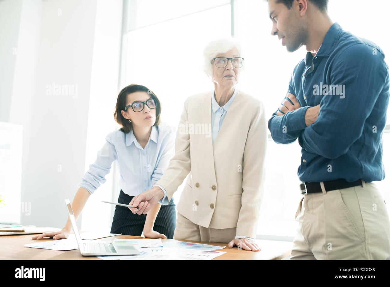 Senior lady explaining analytical data to colleagues Stock Photo - Alamy